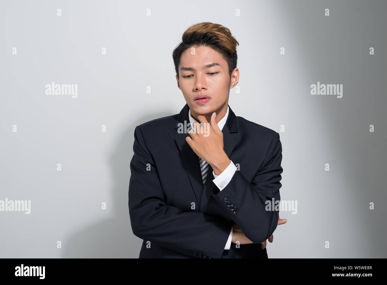 Portrait of young and handsome Asian business man holding a jacket ...
