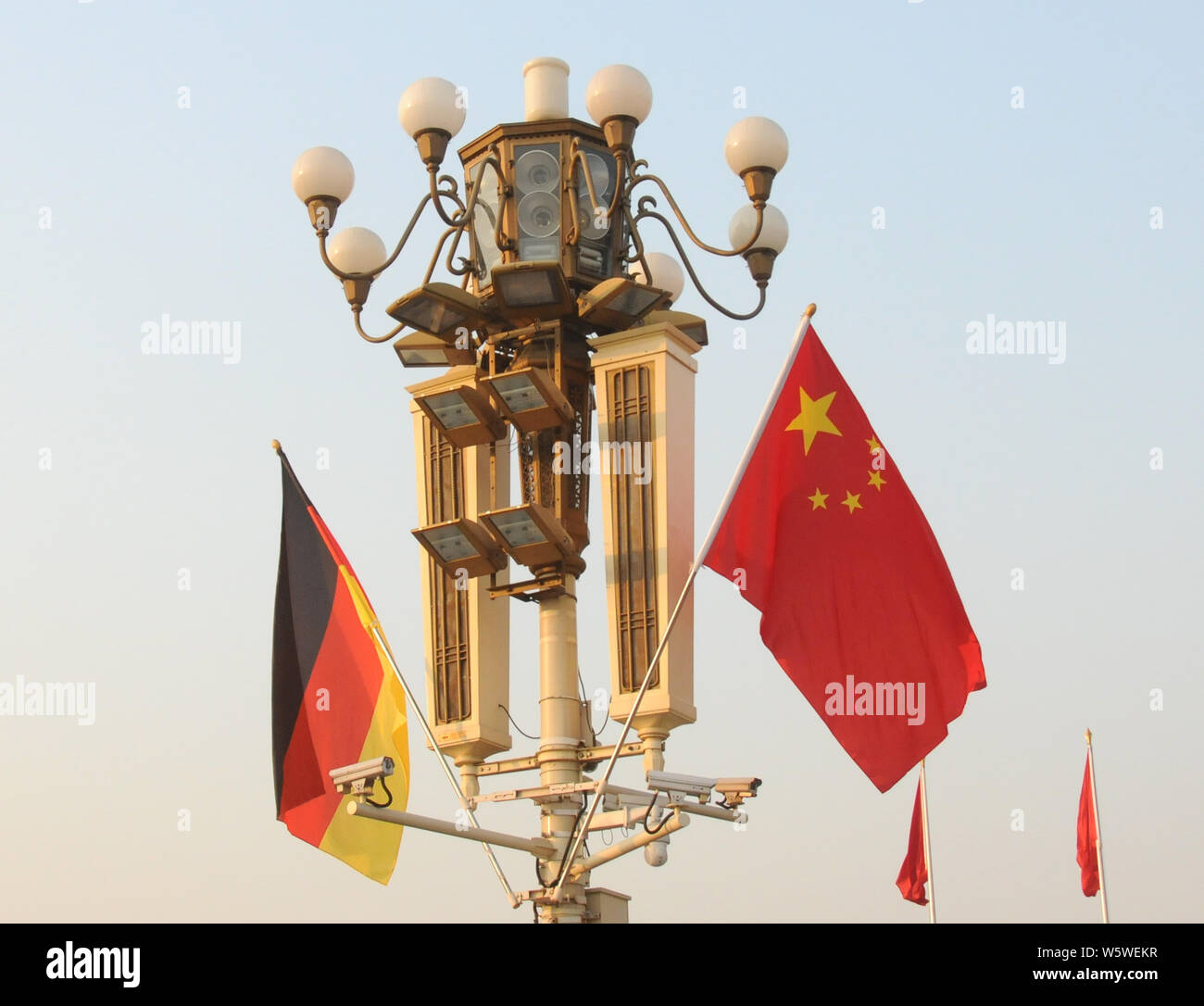 --FILE--Chinese and German national flags flutter on a lamppost in ...