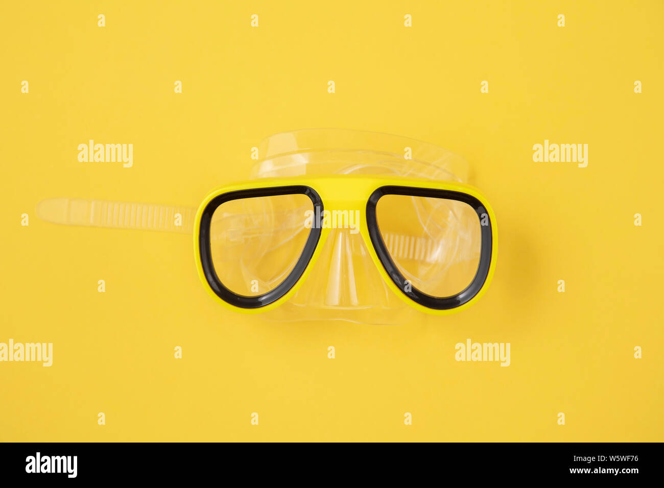 A yellow snorkel and diving mask on a yellow background. overhead lay ...