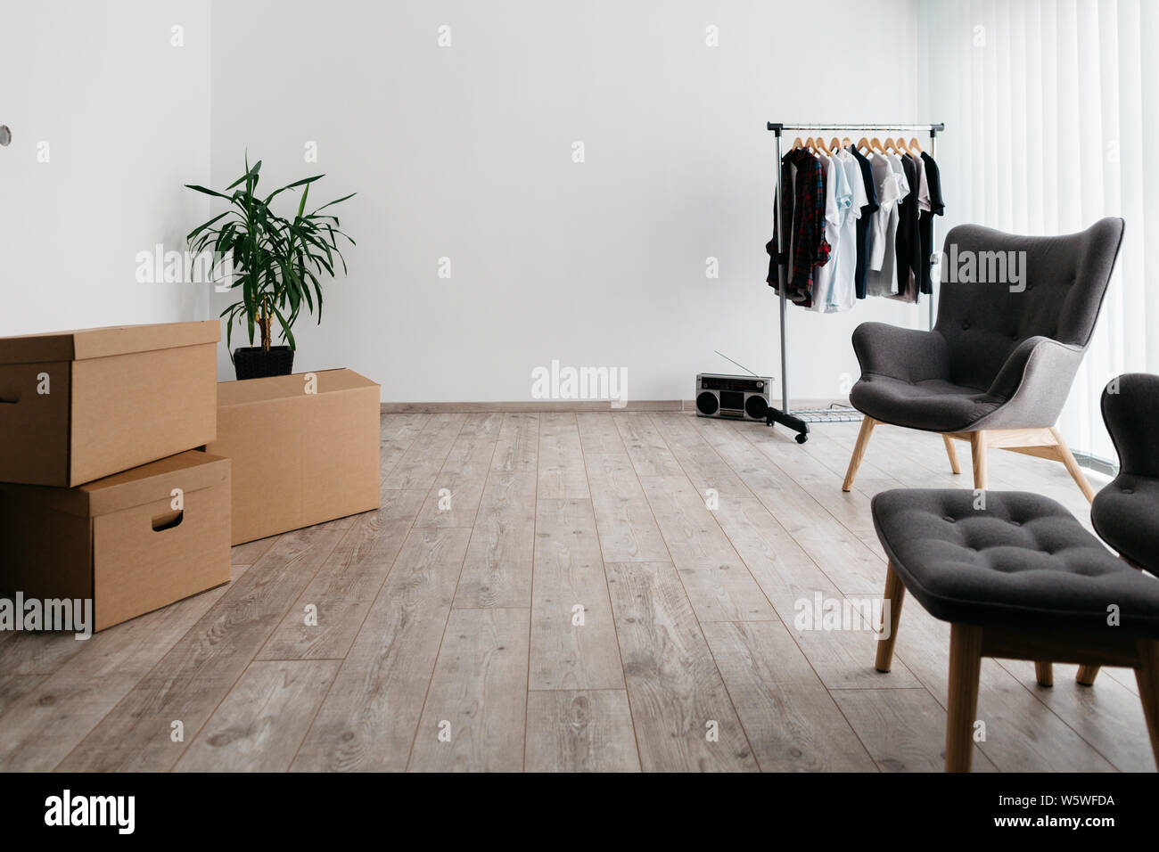 Cardboard boxes in new living room. Moving into new hose - empty room ...