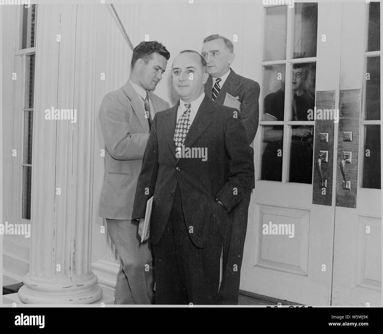 Photograph of a reporter and two unidentified men outside the White ...