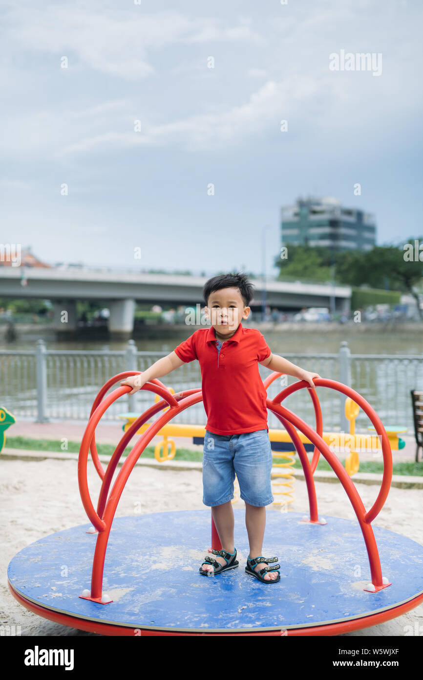 Little asian boy riding a swing and rejoices Stock Photo - Alamy