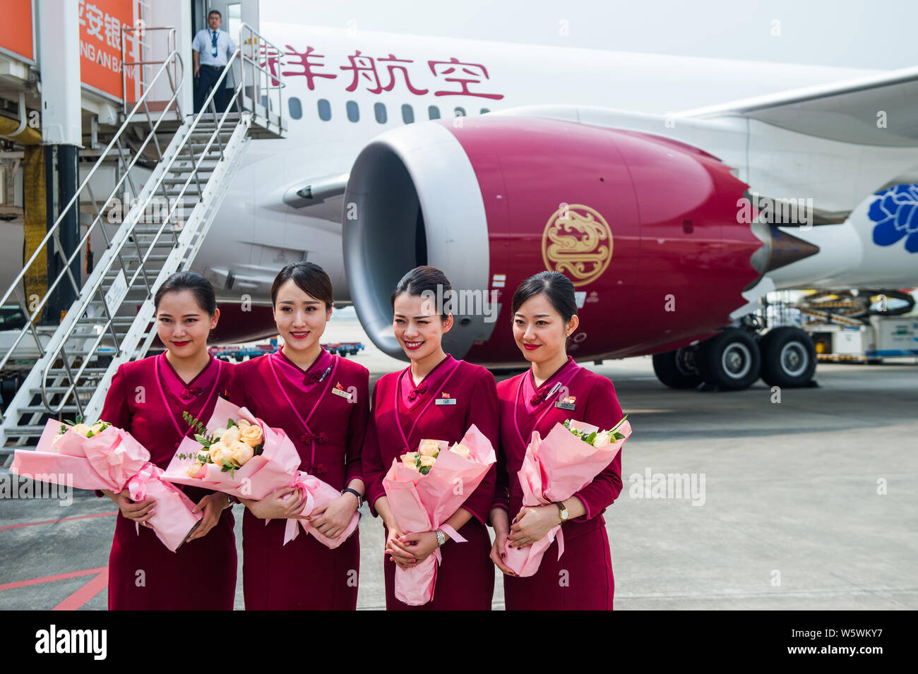 Chinese crew members stand in front of the Boeing 787-9 Dreamliner of ...