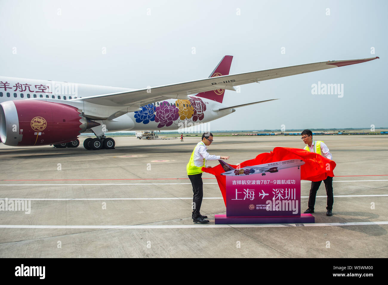Chinese crew members place a signboard in front of the Boeing 787-9 ...