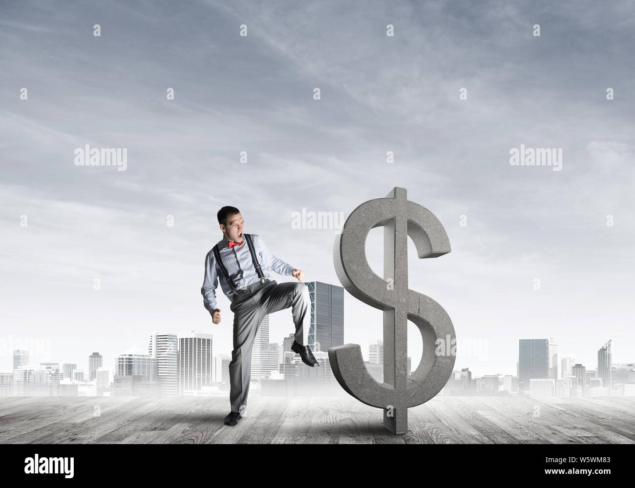 Young furious businessman going to crash with kick stone dollar symbol ...