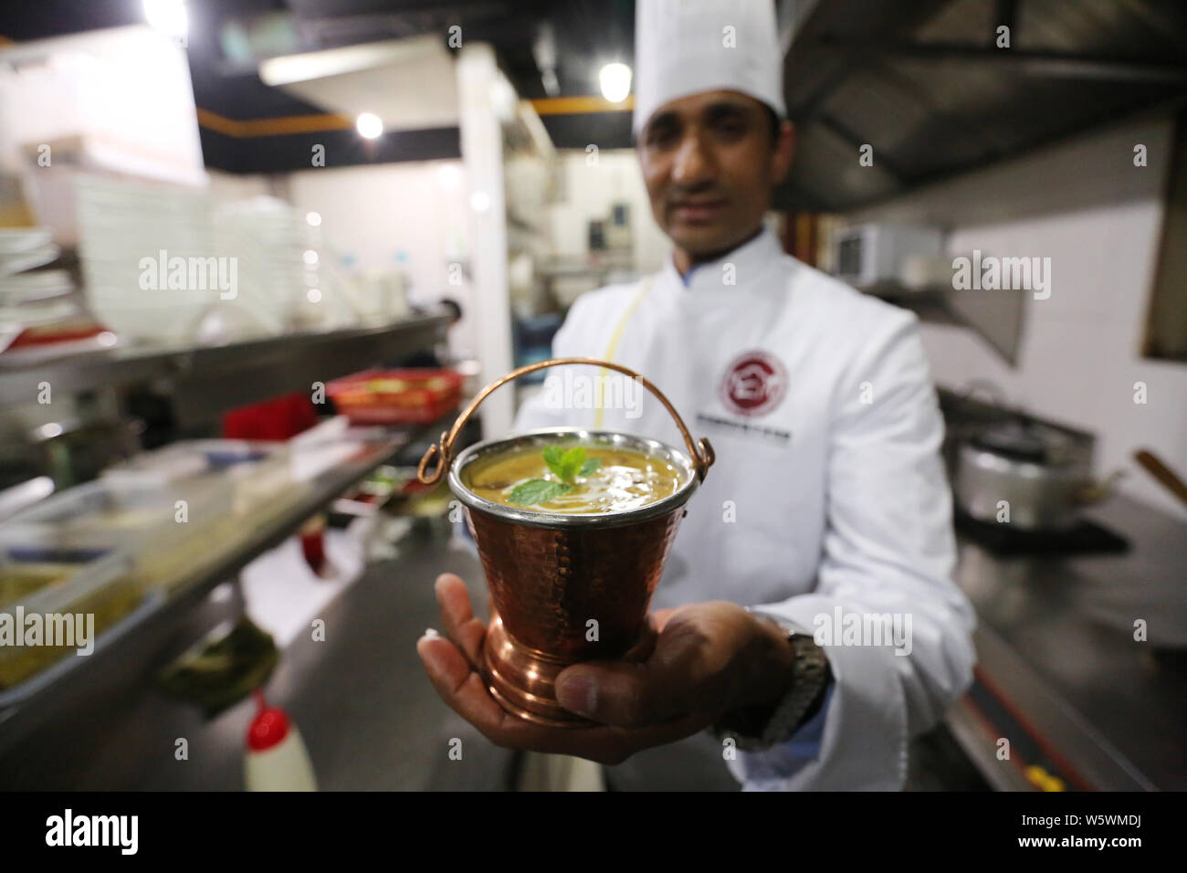 Indian man Dev Raturi, who owns eight restaurants, makes dishes at his ...