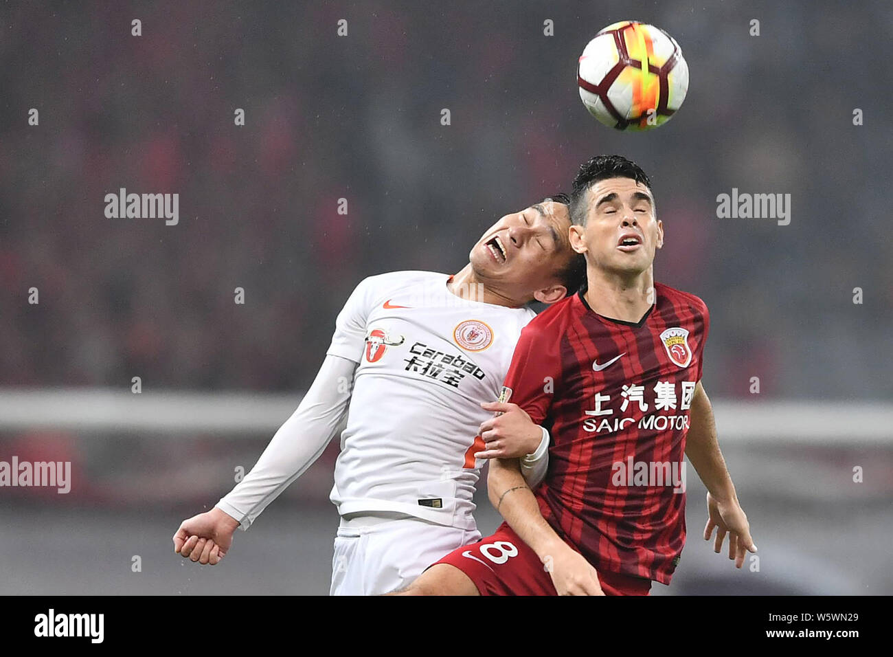 Brazilian football player Oscar, right, of Shanghai SIPG heads the ball ...