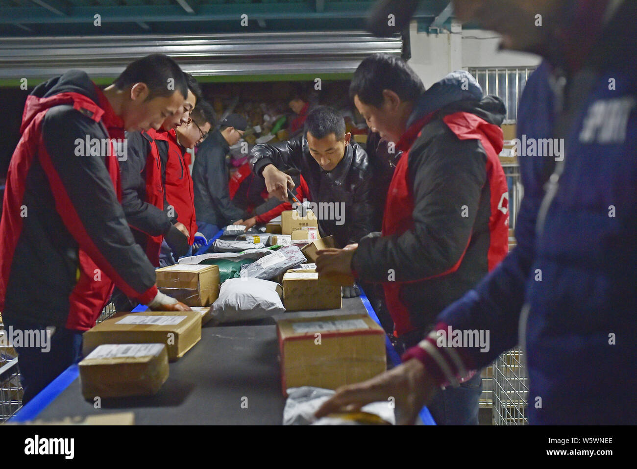 Chinese workers sort out parcels, most of which are from Singles' Day online shopping, at a ...