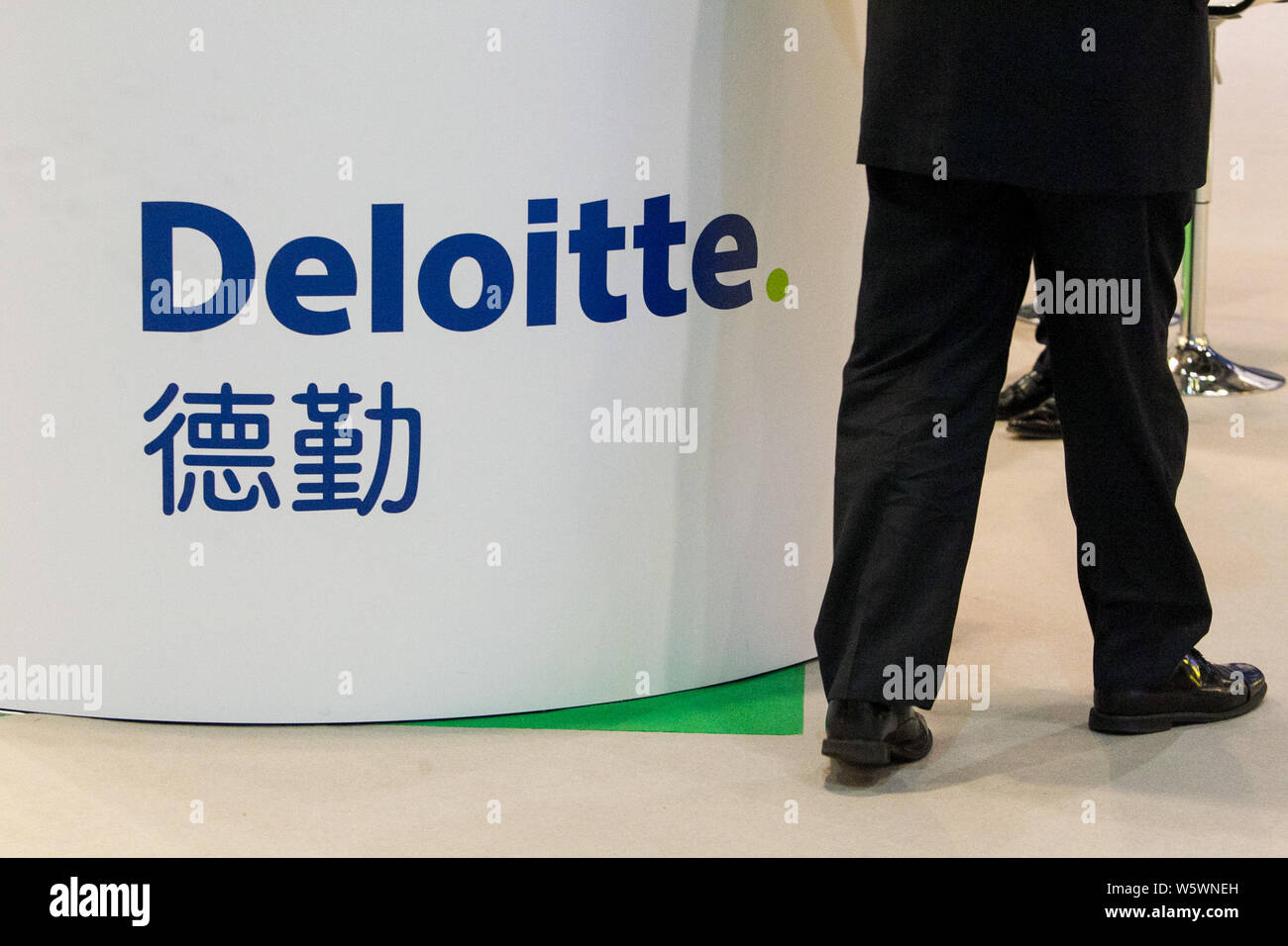 --FILE--A visitor walks past the stand of Deloitte during an exhibition in Hong Kong, China, 19 ...