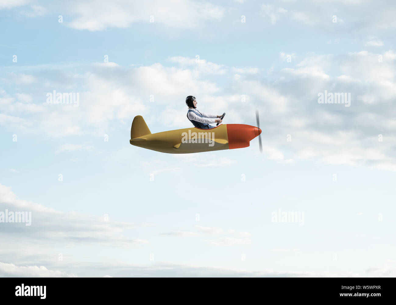 Happy pilot driving small propeller plane on background of blue sky ...