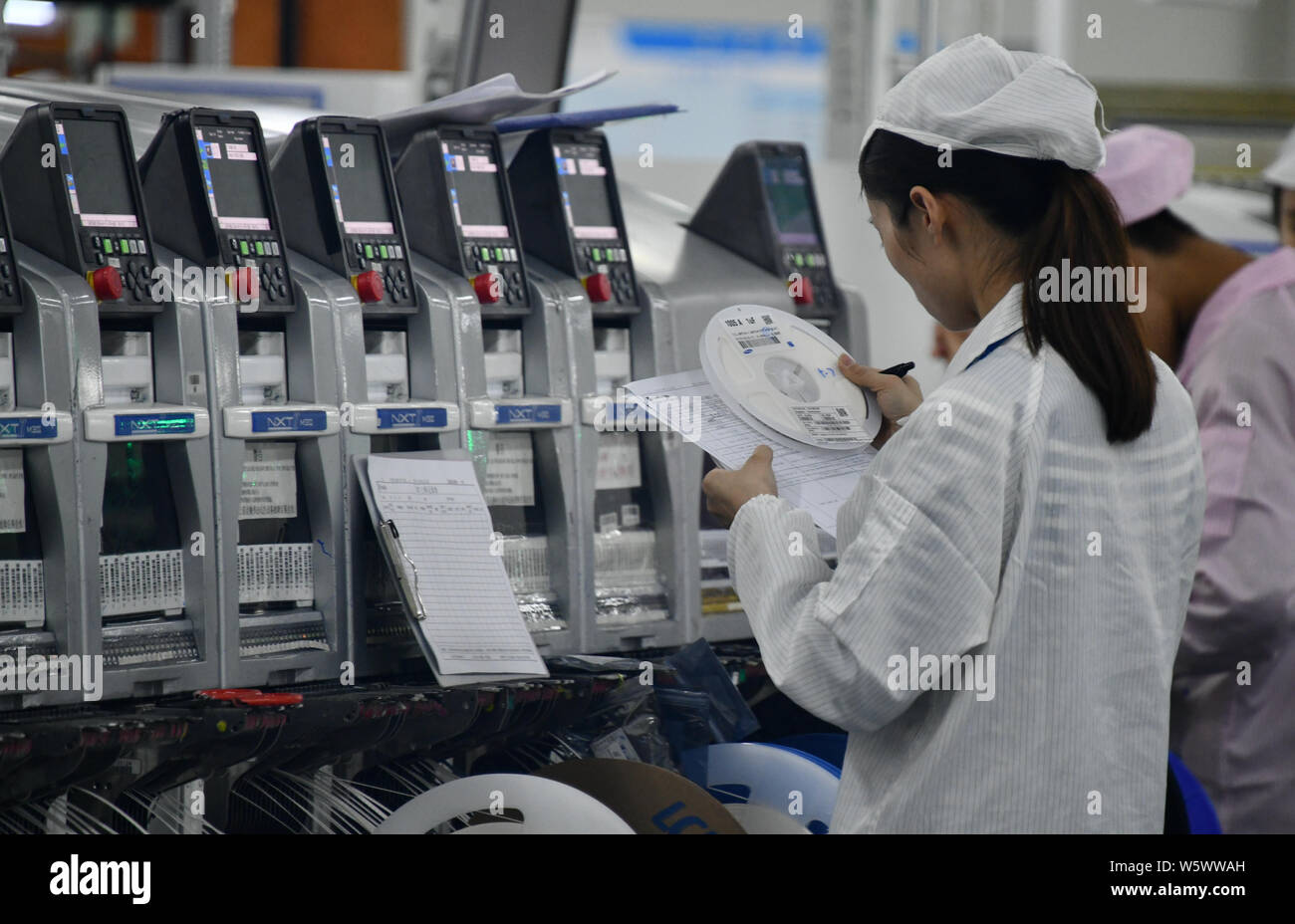 A Chinese worker checks intelligent products on the assembly line at a ...