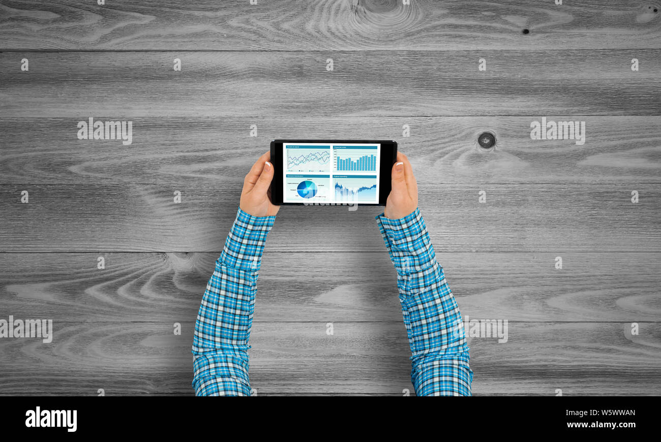 Top view of girl hands using tablet pc with diagrams and graphs on ...