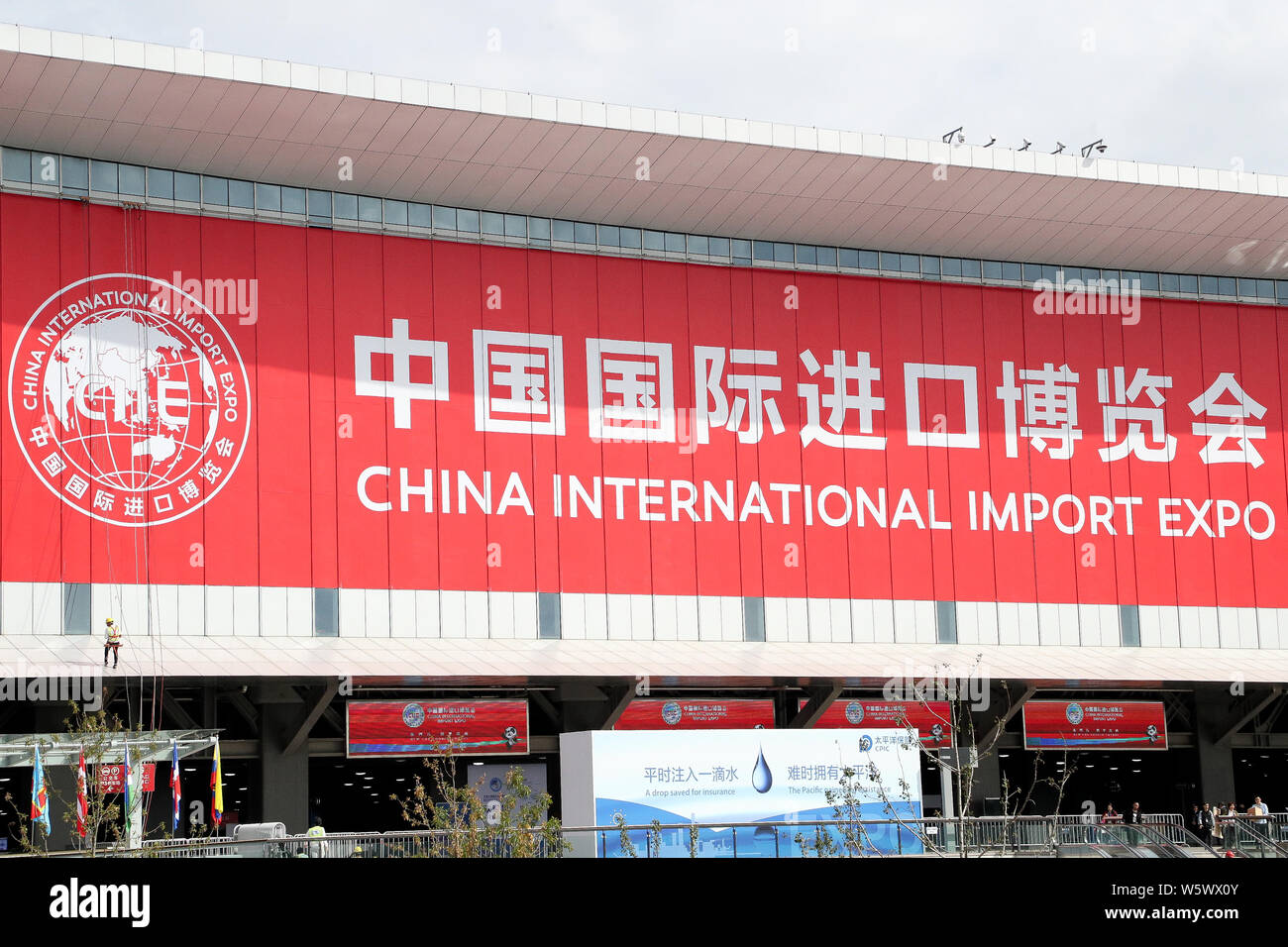 A Chinese worker installs the signboard for the China International ...
