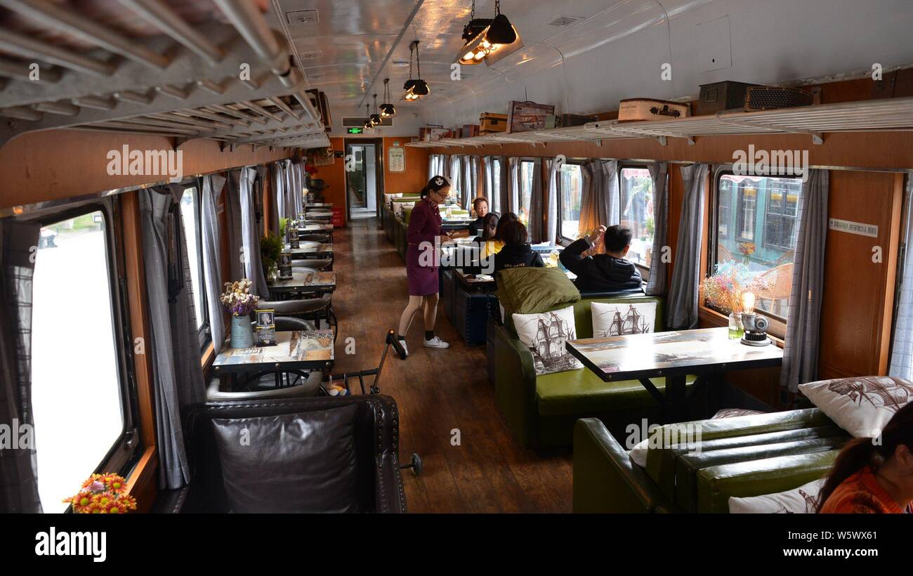 A waitress dressed as a train attendant serves customers at a ...