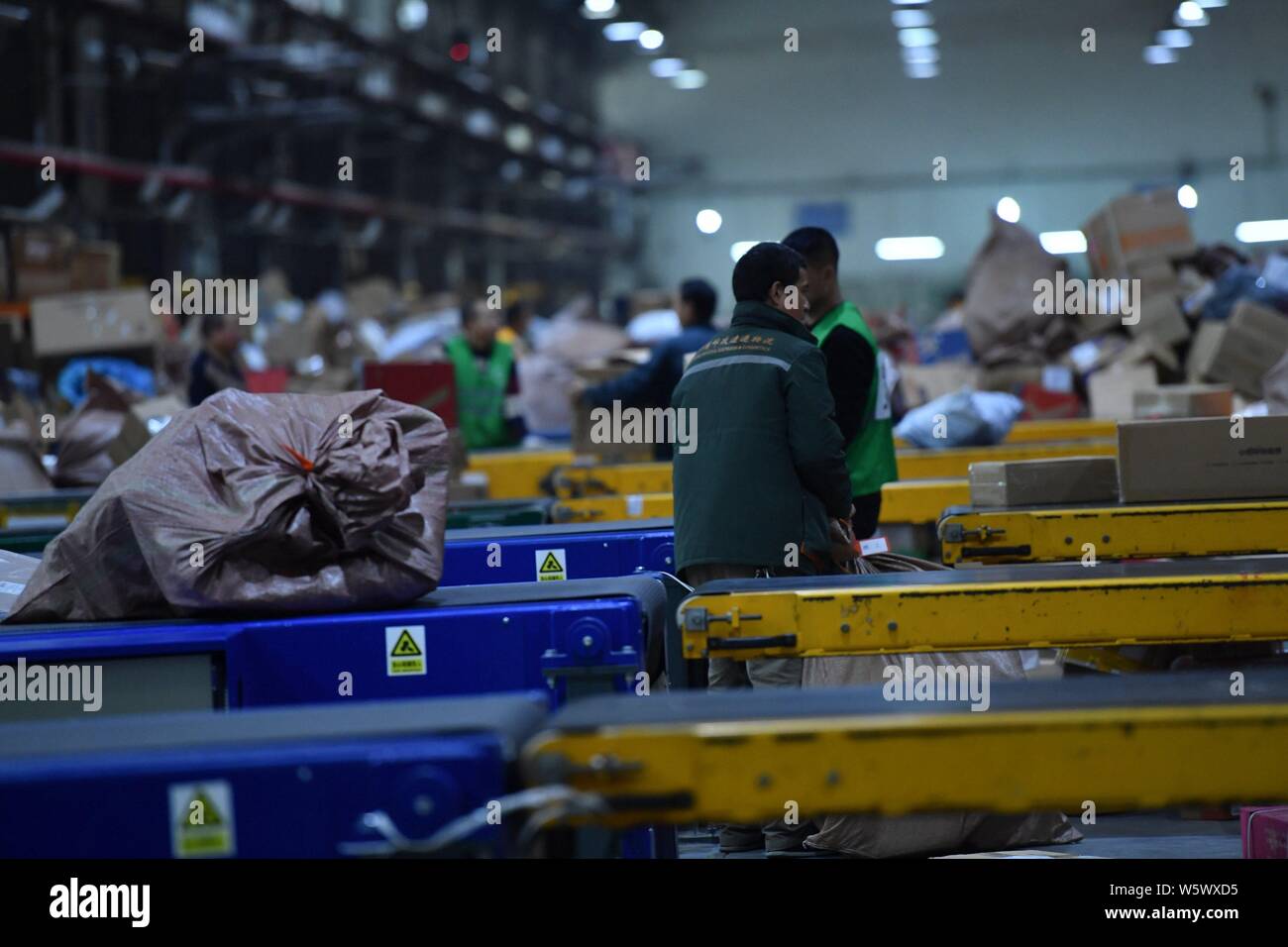 Chinese workers deal with parcels, most of which are prepared for ...