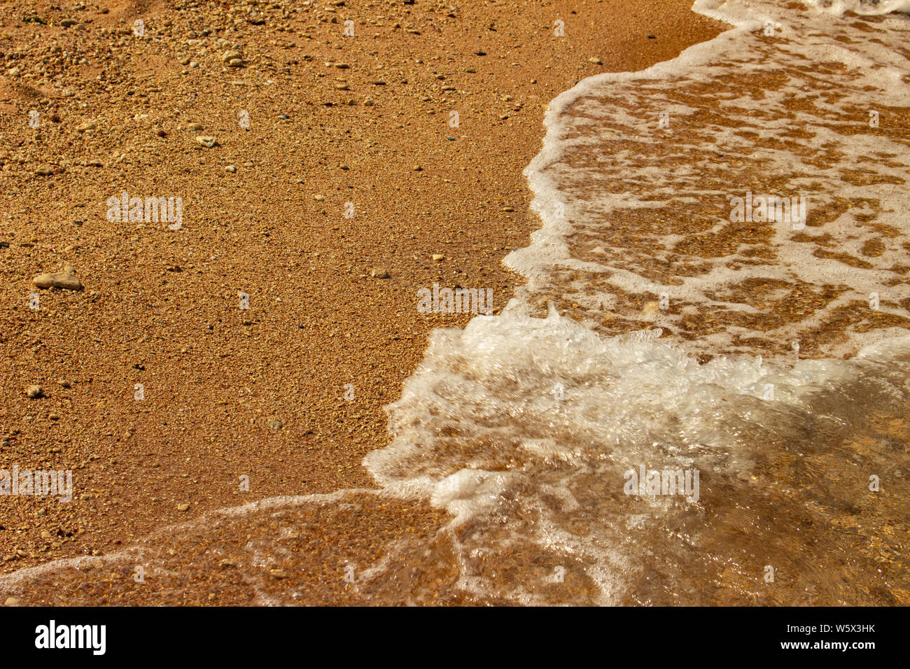 Summer background of hot sand with sea or ocean wave bubbles with copy ...