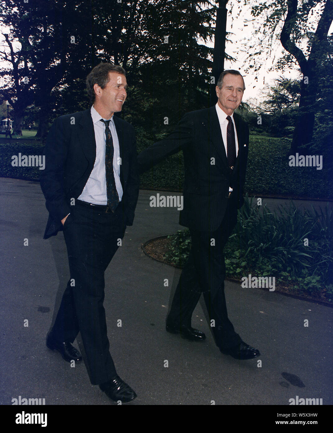 President Bush walks up the South Lawn towards the Oval Office with his ...