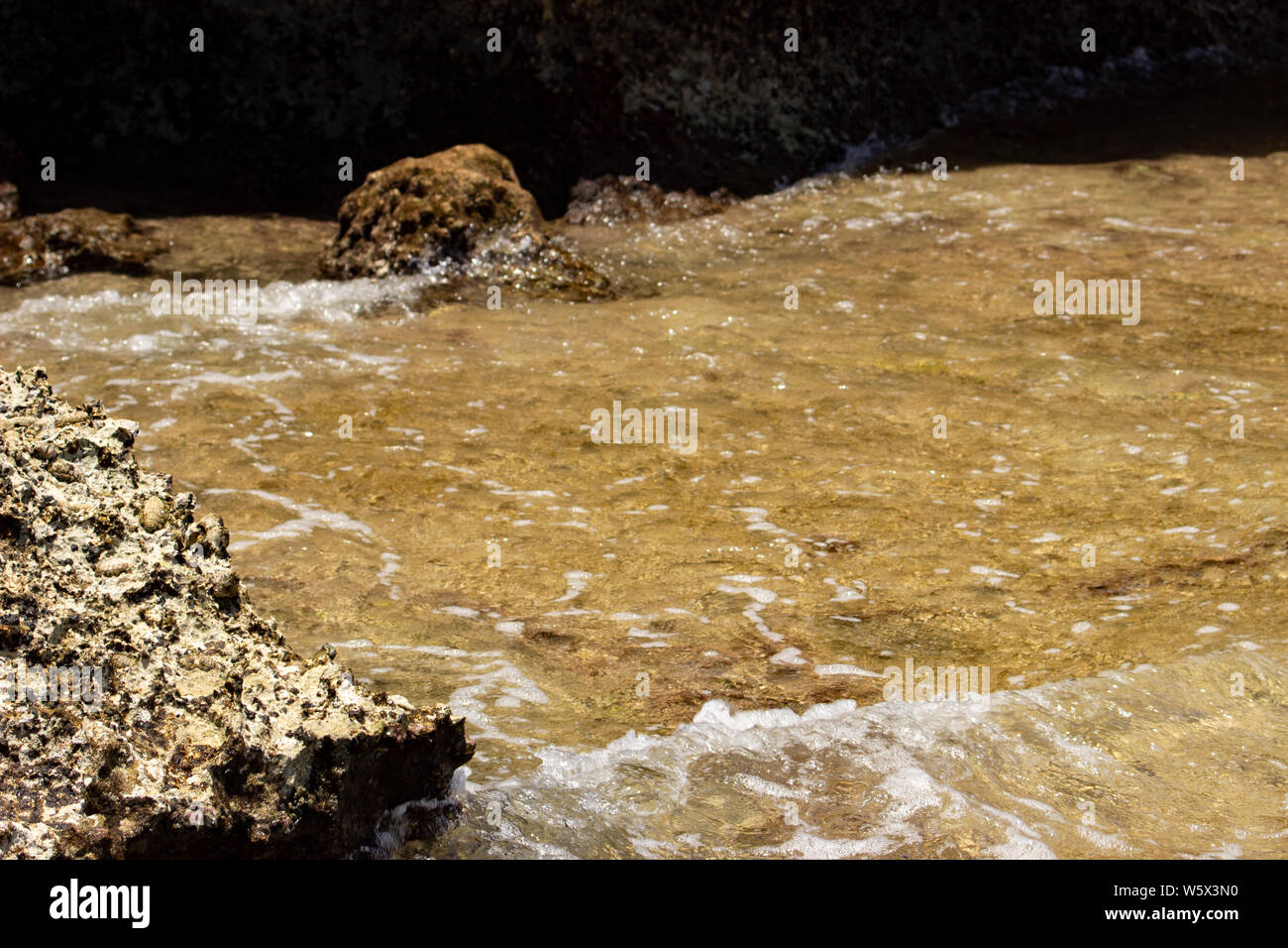 Summer background of hot sand with sea or ocean wave bubbles with copy ...