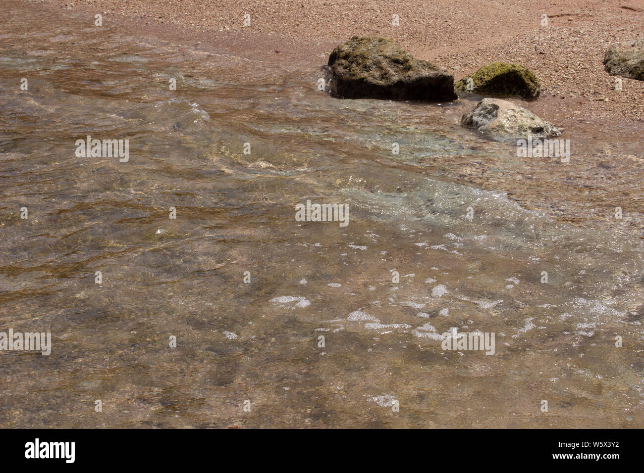 Summer background of hot sand with sea or ocean wave bubbles with copy ...