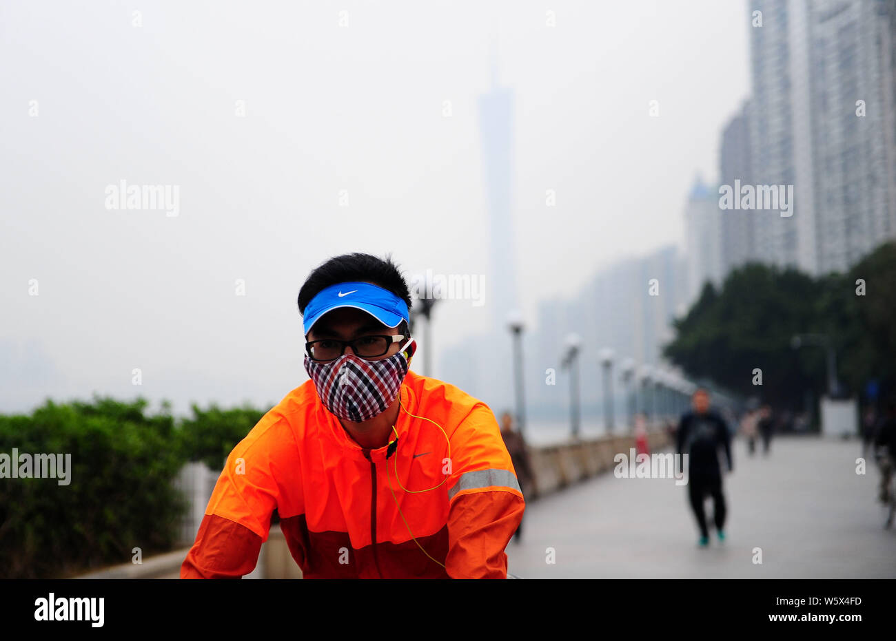 --FILE--A cyclist wearing a face mask against air pollution rides in ...