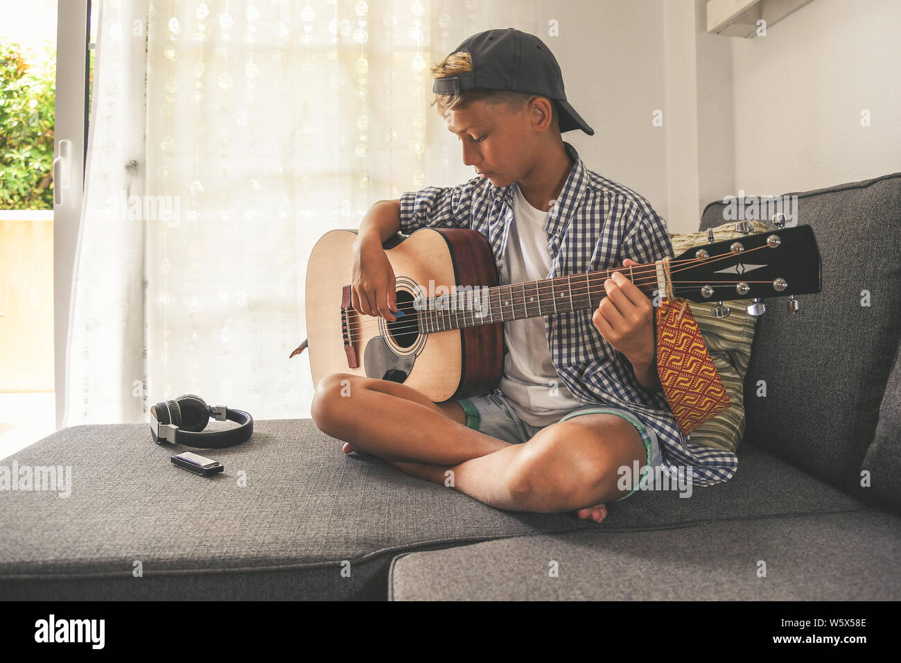 Beautiful young boy playing acoustic guitar. Music student exercises ...
