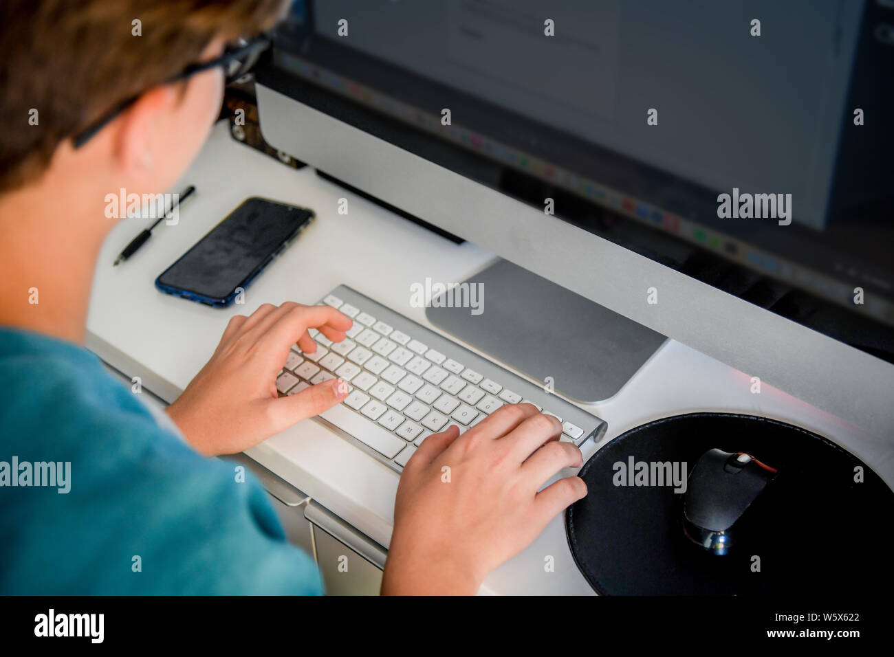 Beautiful teen doing homework with computer. Teenager working online ...