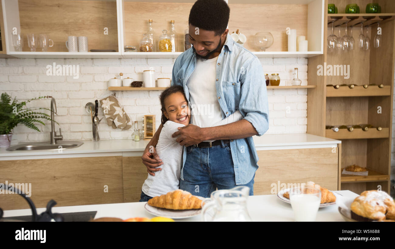 Grateful afro girl hugging her father before breakfast Stock Photo - Alamy