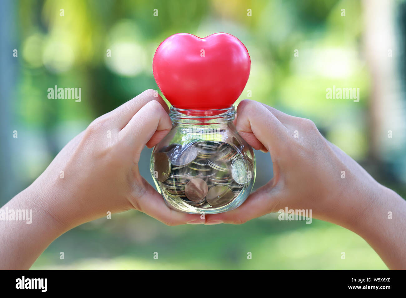 human hands saving money and do heart symbol sign Stock Photo - Alamy