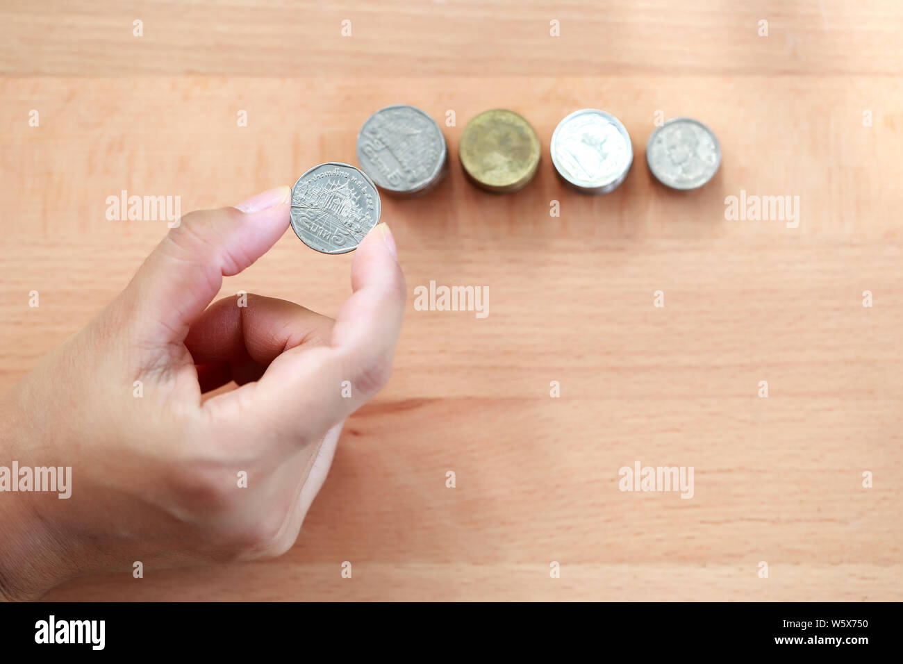 human hand saving money on stacking coins Stock Photo - Alamy