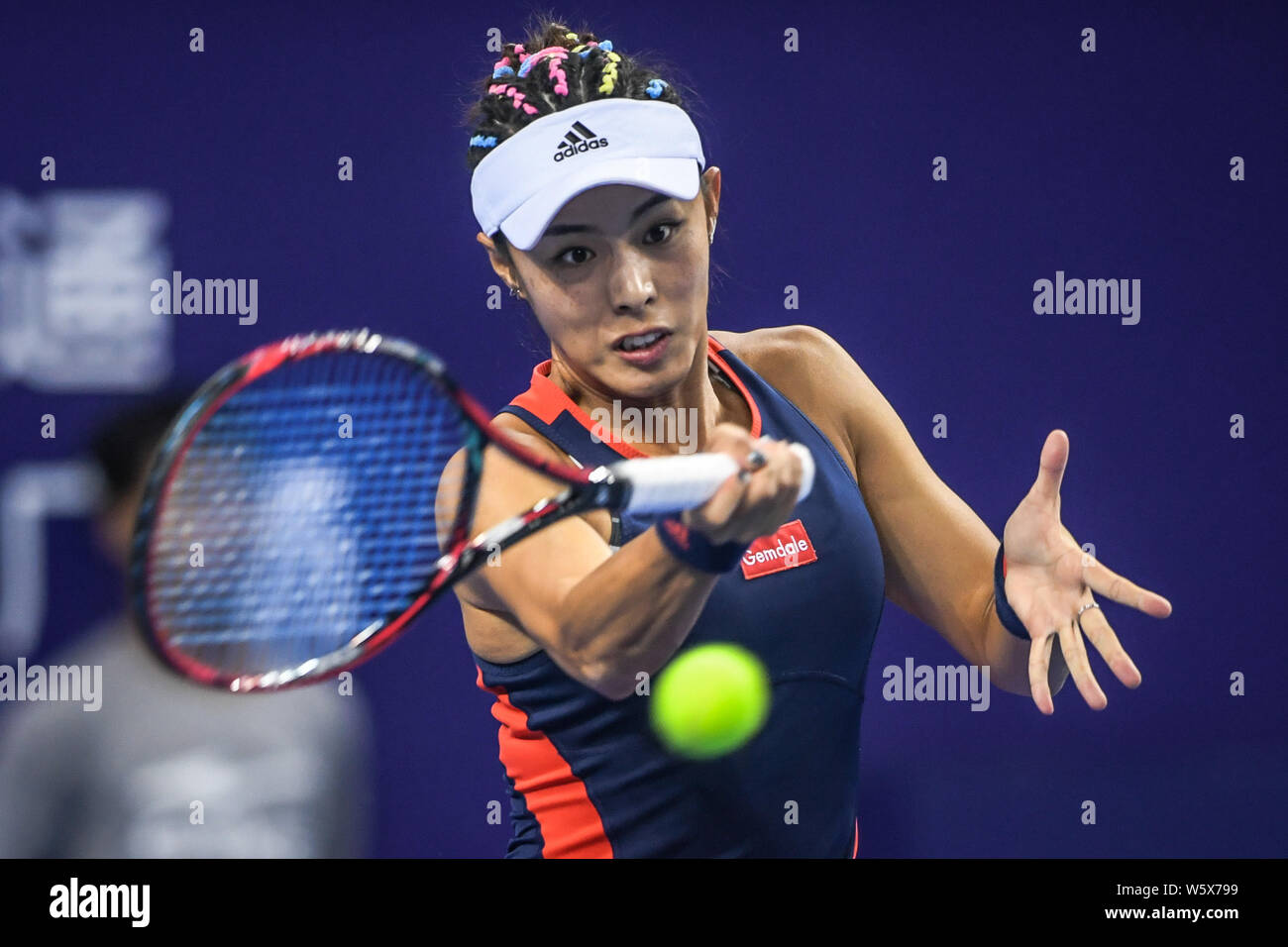 Wang Qiang of China returns a shot to Madison Keys of the United States ...