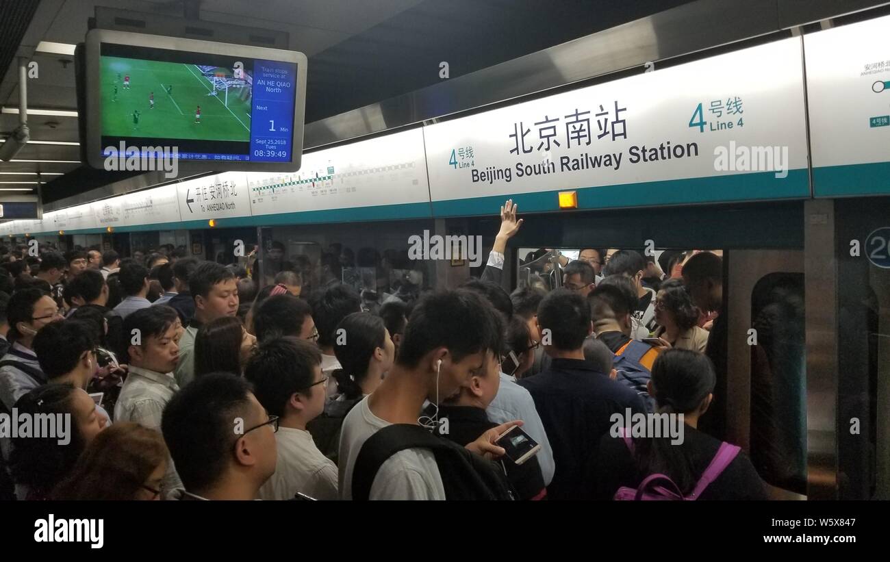 --FILE--A crowd of Chinese commuters rush into a Metro train at a ...