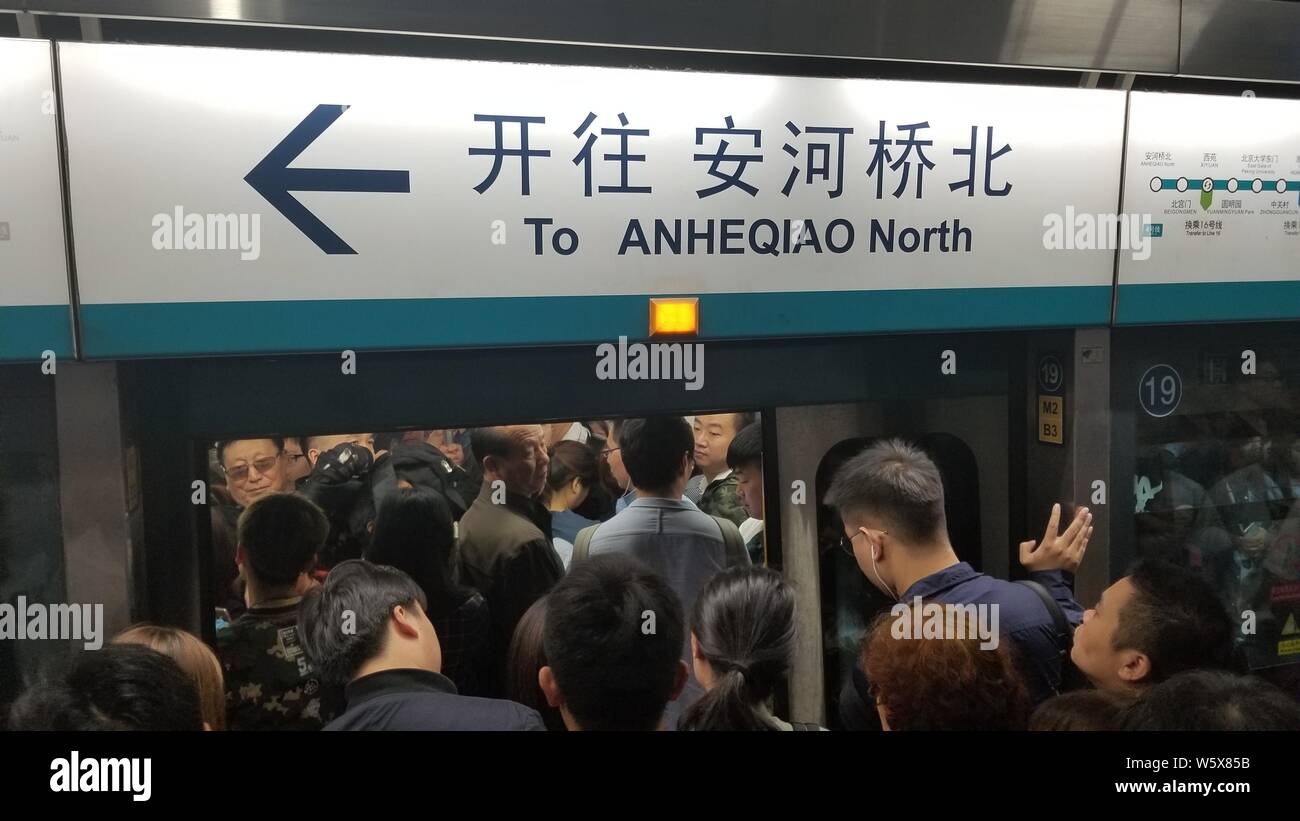 --FILE--A crowd of Chinese commuters rush into a Metro train at a ...