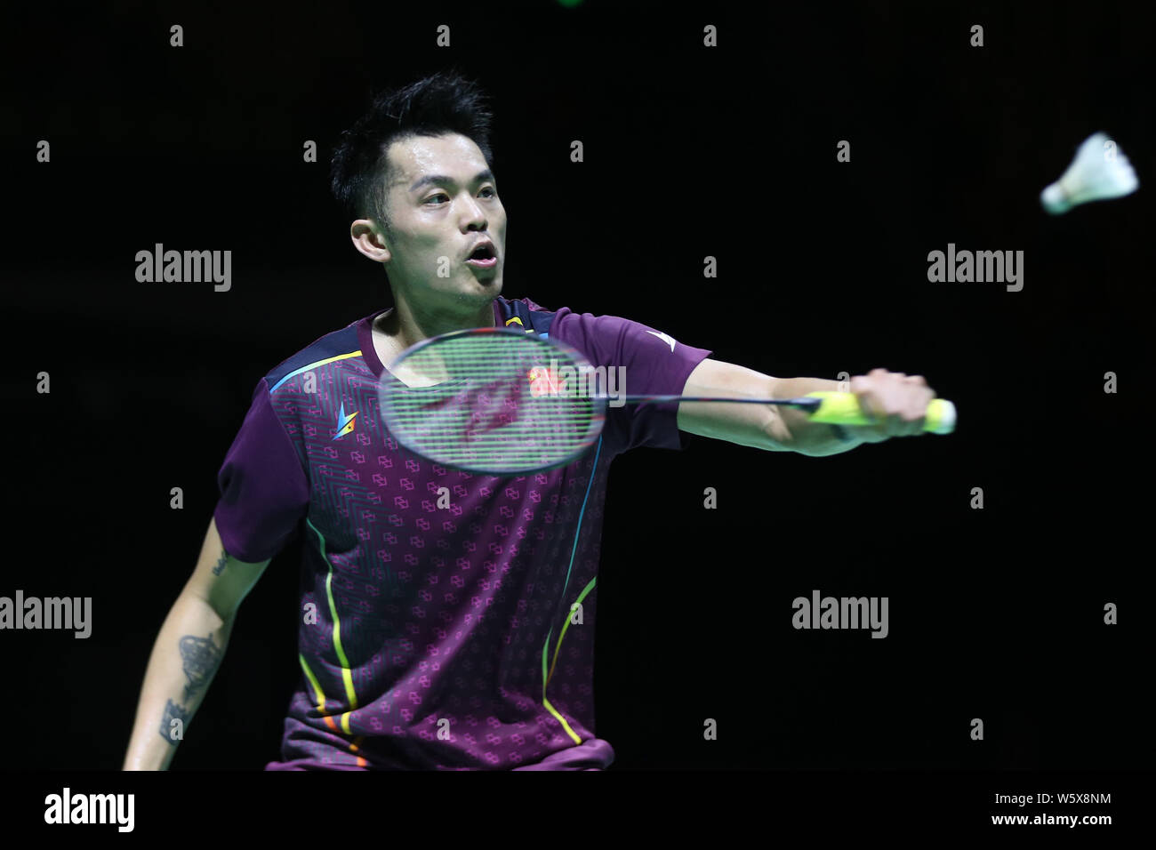 Lin Dan of China plays a shot to Kento Momota of Japan in the first ...