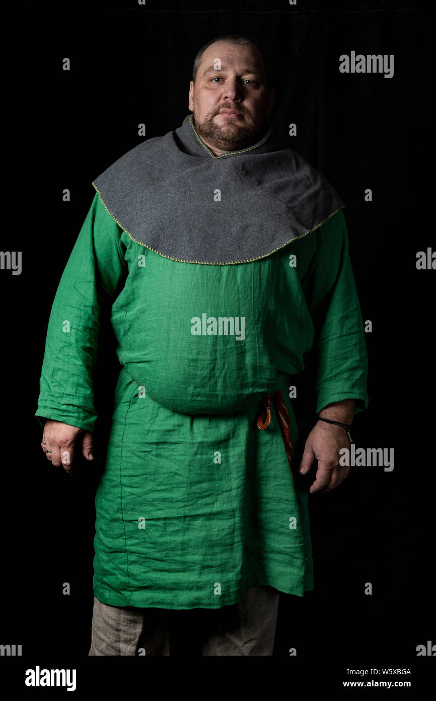 Viking dressed in a green shirt and a hood. mature overweight man in ...