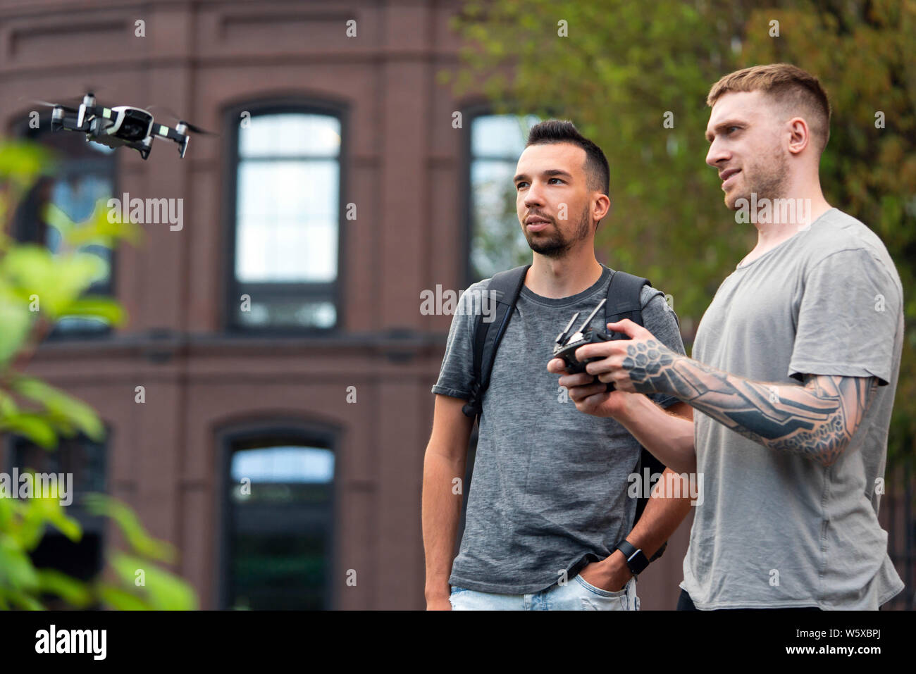 Young handsome men launching drone quadcopter at urban background ...