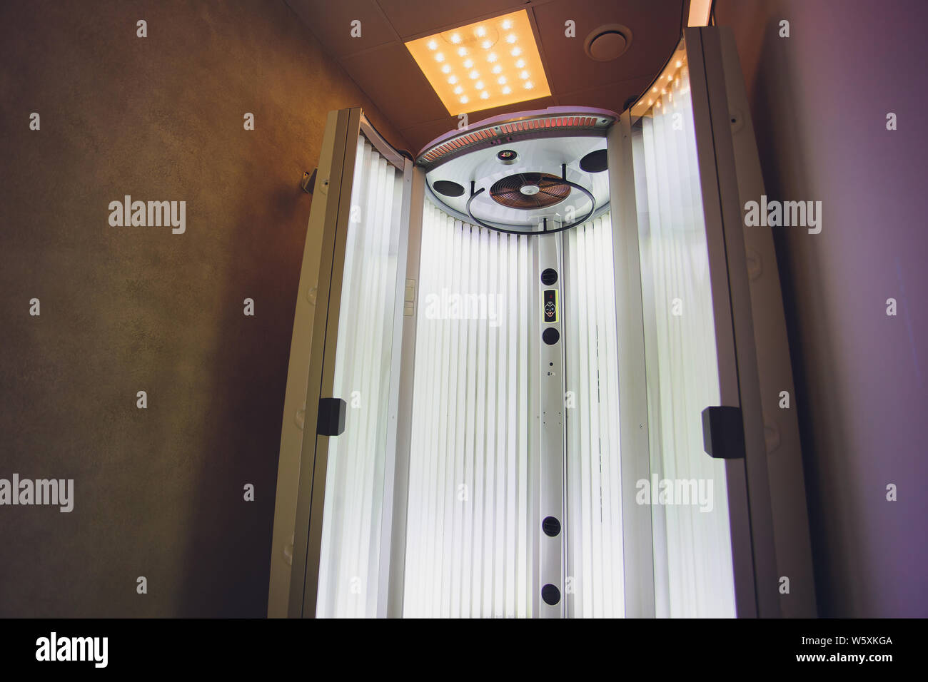 Vertical Tanning turbo Solarium Light Machine with glowing blue light ...