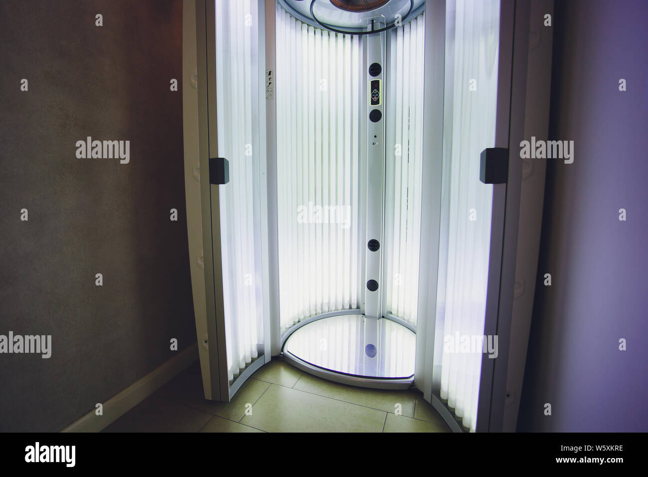 Vertical Tanning turbo Solarium Light Machine with glowing blue light ...