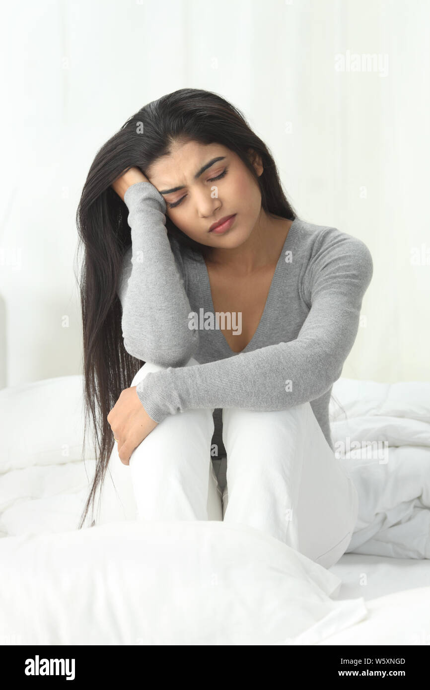 Depressed woman sitting on the bed Stock Photo - Alamy