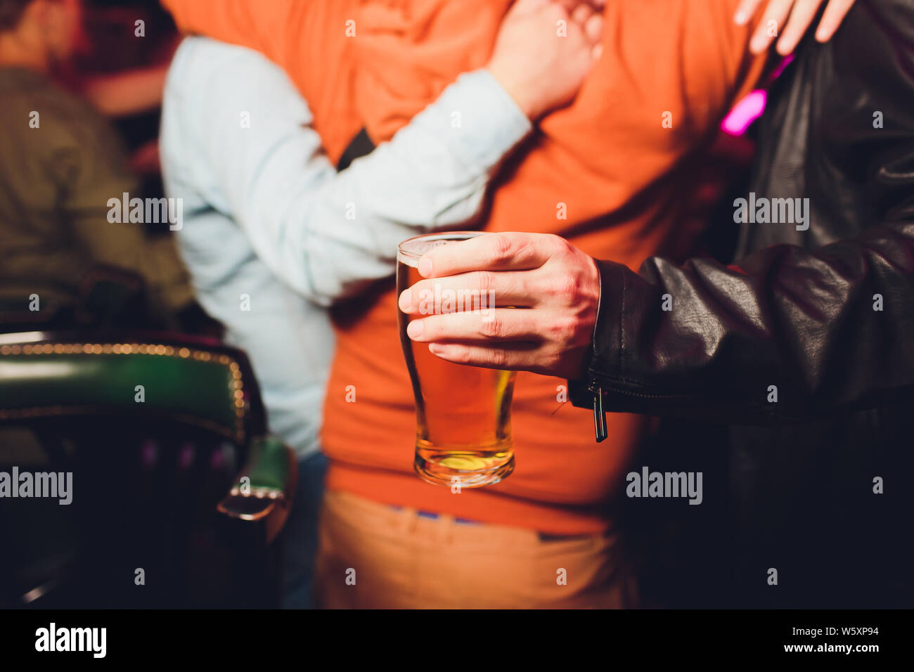 Cocktail glass in woman's hand with bar on back Stock Photo - Alamy