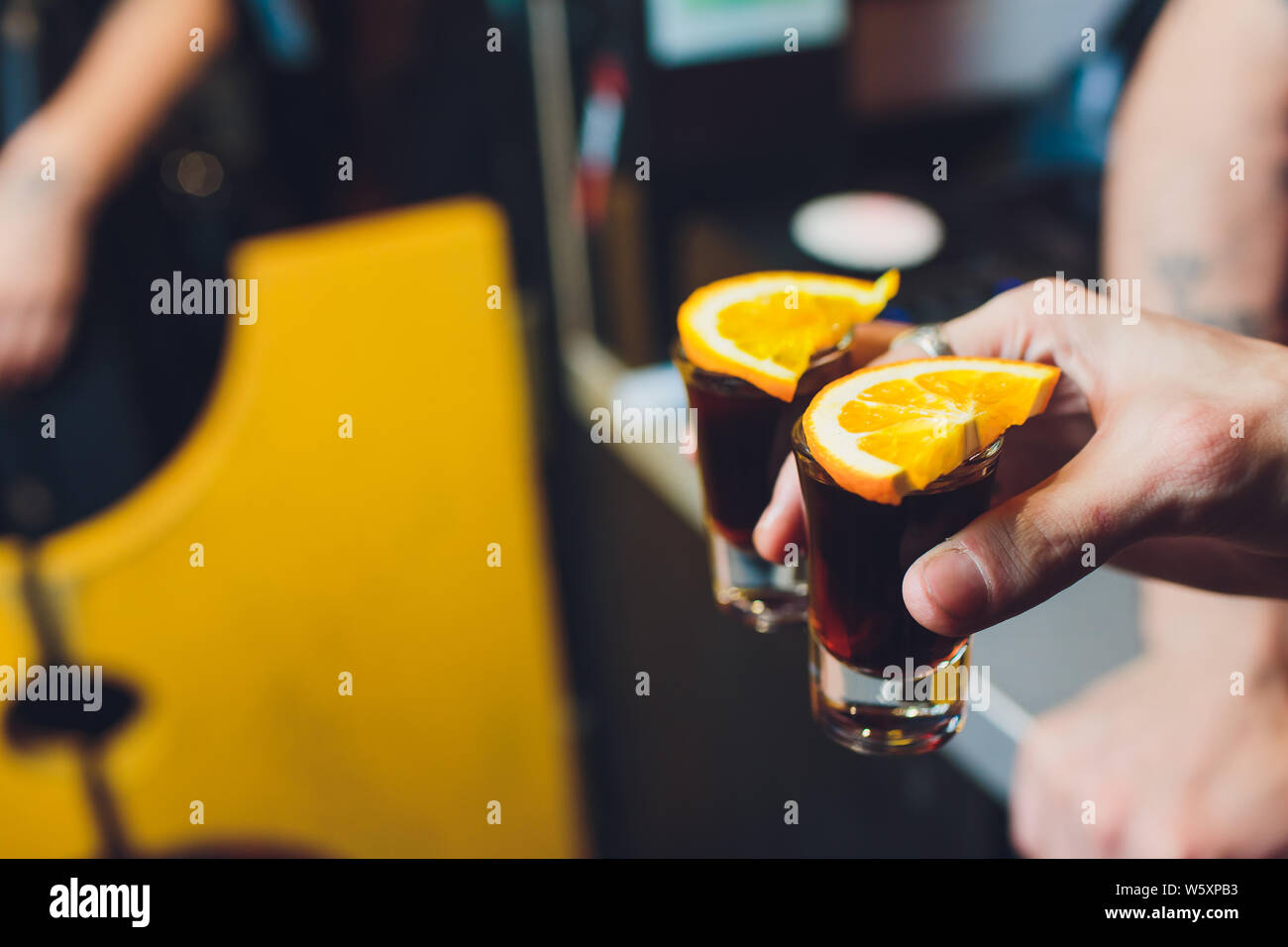 Male hands cheer with glasses of shot or liqueur. Friends drink shot or ...