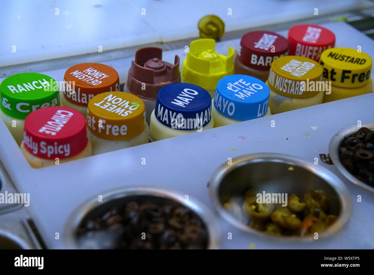 Colored labeled sauce and sandwich condiments in its storage bin Stock ...
