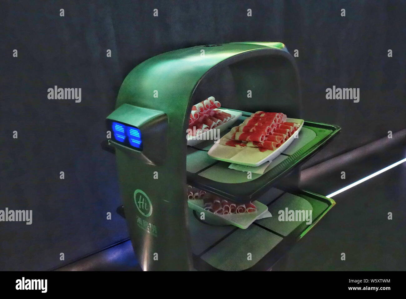 A robot waiter delivers dishes ordered by customers to the table at the ...