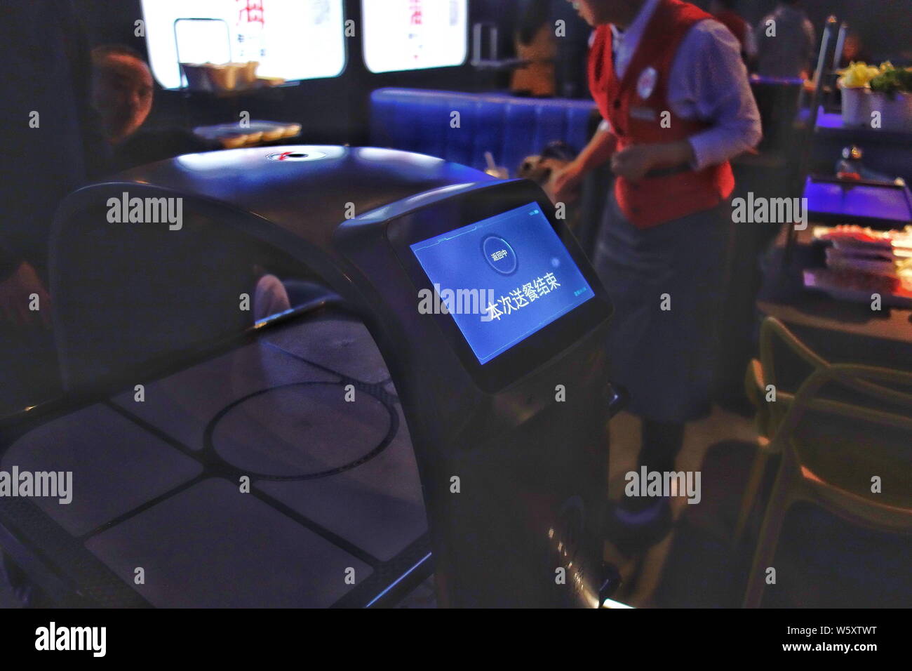 A robot waiter delivers dishes ordered by customers to the table at the ...