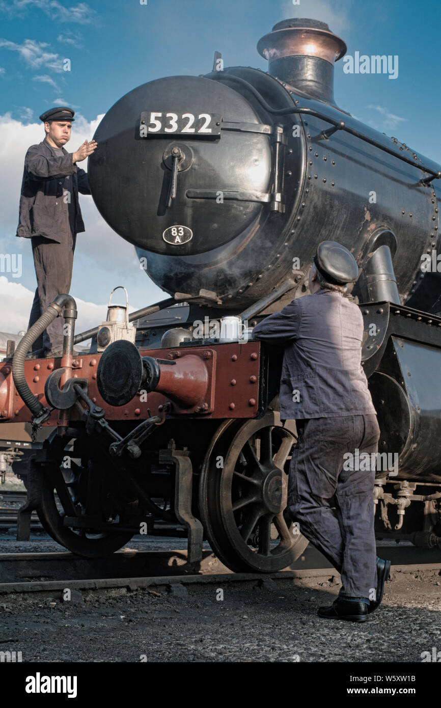 Re-enactors pose in front of a locomotive creating a nostalgic scene ...