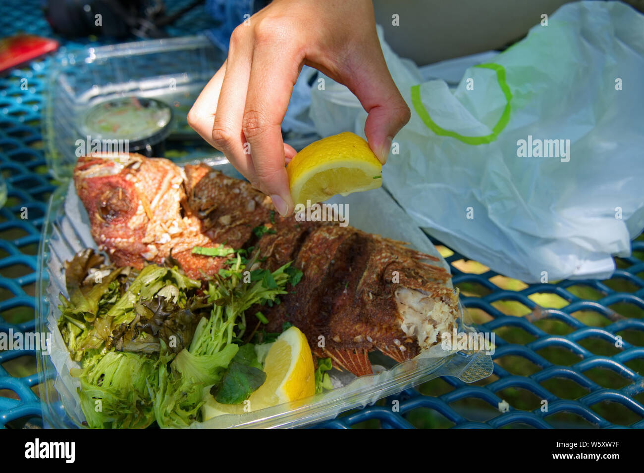 Hand squeezing lemon over fried hi-res stock photography and images - Alamy