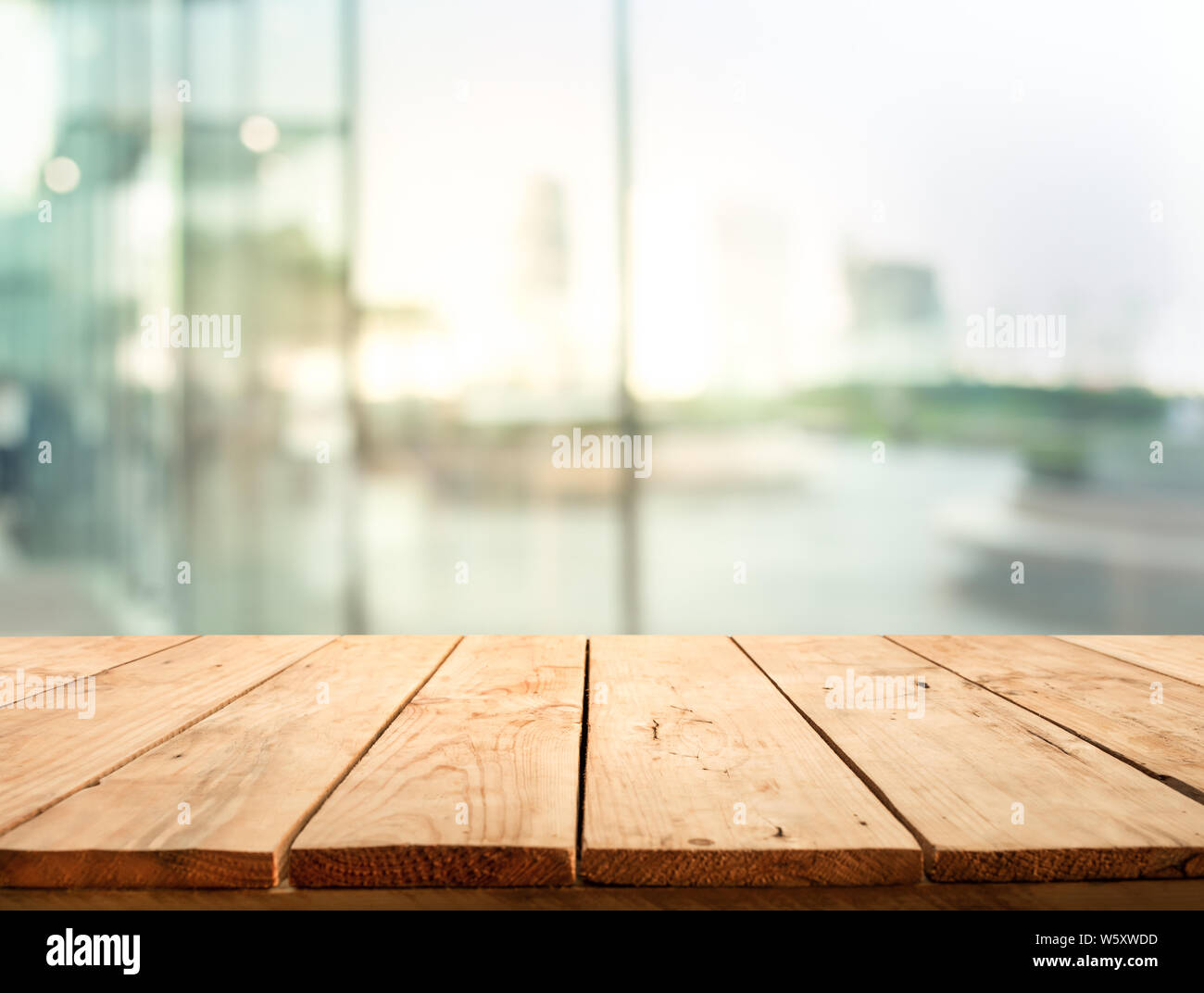Wood table top on blur window glass,wall background with city view.For ...