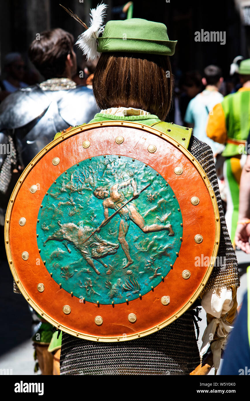 Man dressed in medieval costume wears a shield on his back for the ...