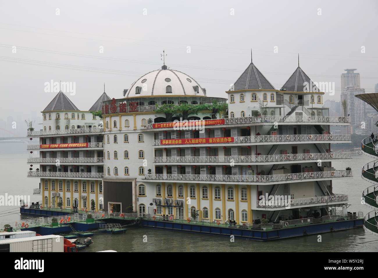 A massive floating restaurant is docked at a port on the Yangtze River ...