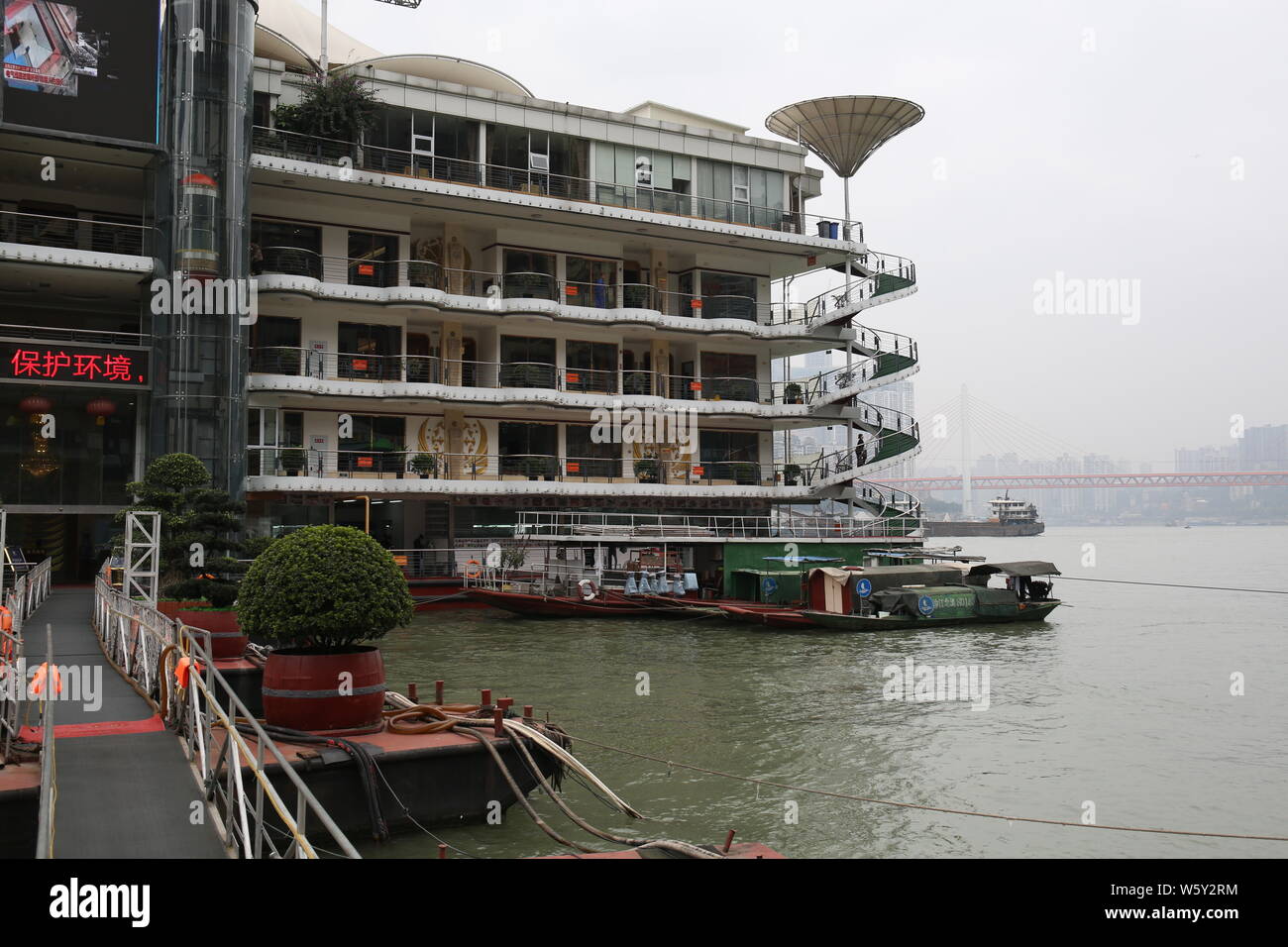 A massive floating restaurant is docked at a port on the Yangtze River ...
