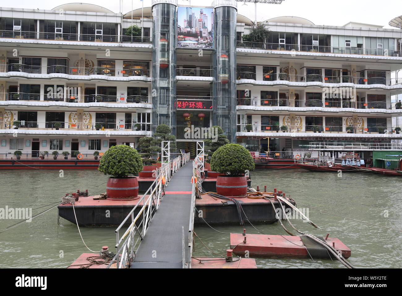 A massive floating restaurant is docked at a port on the Yangtze River ...